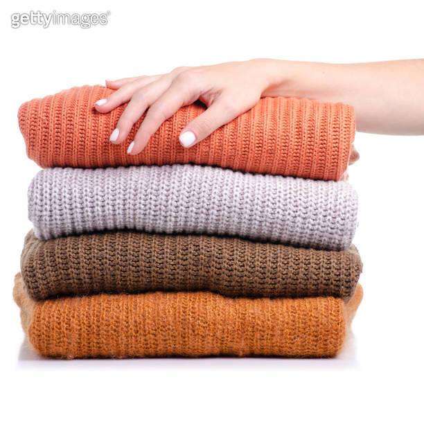 Stack folded sweater clothing hand holding 이미지 (1169752593) - 게티이미지뱅크