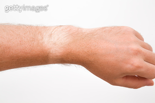 Young man showing not tanned arm skin from watch. Gray background ...