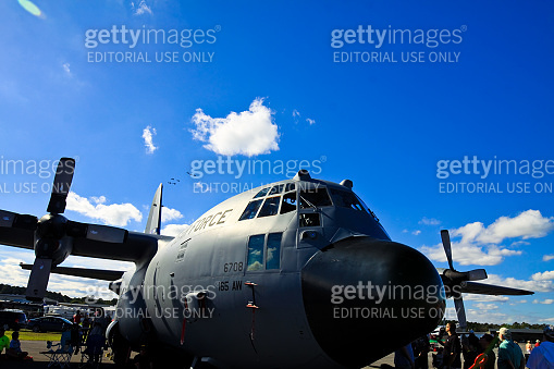 Lockheed C-130 Hercules and Vintage propeller airplane flying together ...