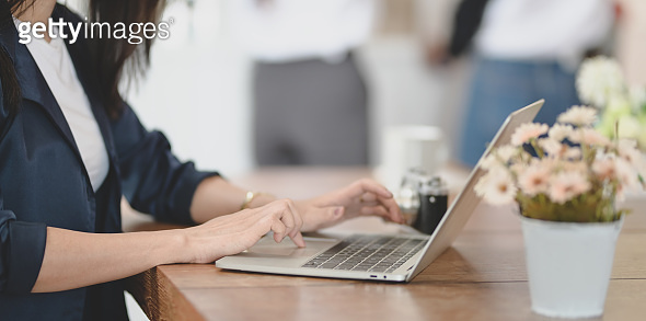 Close-up view of businesswoman typing on laptop computer while working ...