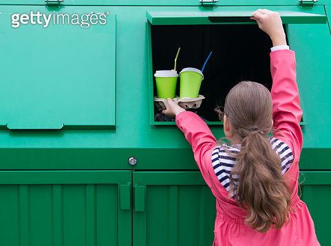 the girl in the pink jacket, throwing disposables in the trash ...
