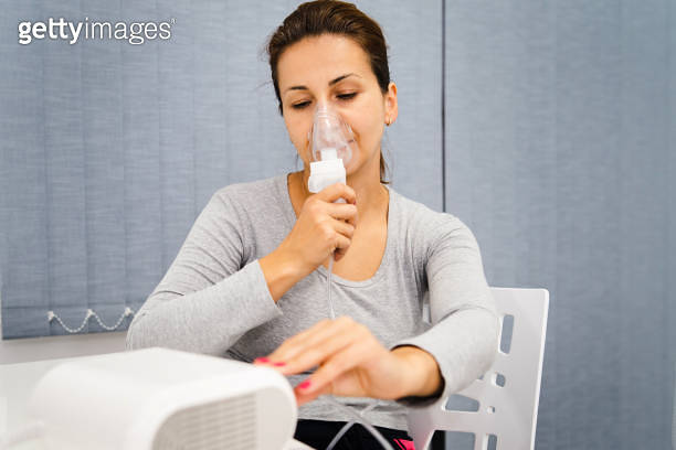 Portrait of adult woman using steam vapor inhaler nebulizer doing ...