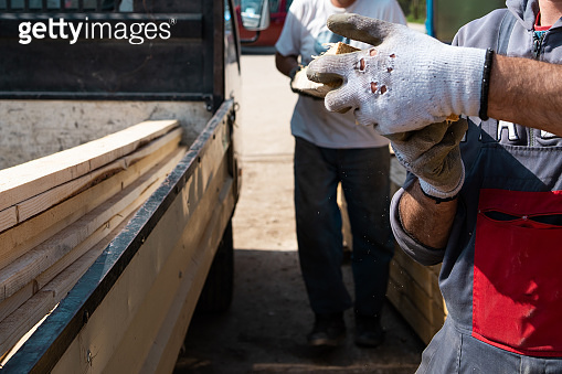 Workers holding material planks by the truck ready to delivery to the ...