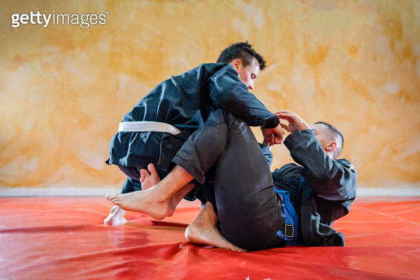 Two brazilian jiu jitsu athletes working on BJJ guard position at the ...