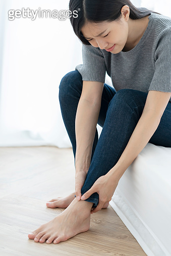 asian unhealthy woman feel hurt hand touch feet or leg with unhappy ...