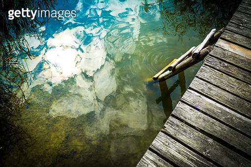 Old wooden platform on the lake with a ladder into the water ...