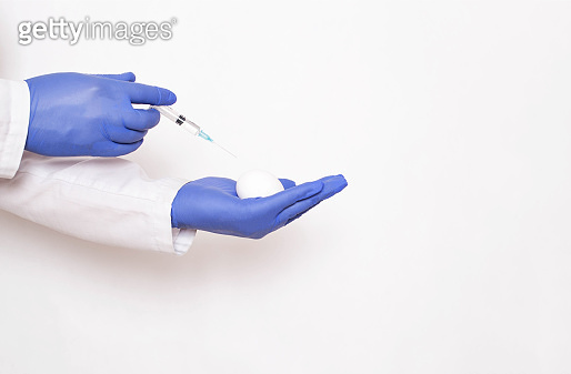 Doctor cosmetologist injecting Botox into an egg is a concept of ...