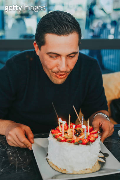 man blowing out candles on the cake, birthday 이미지 (1184712950) - 게티이미지뱅크