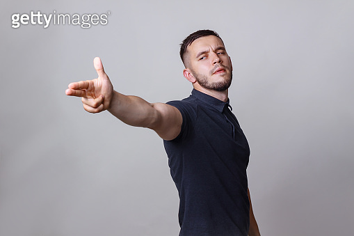 Portrait of a young man shooting gesture. Handsome straightened his ...