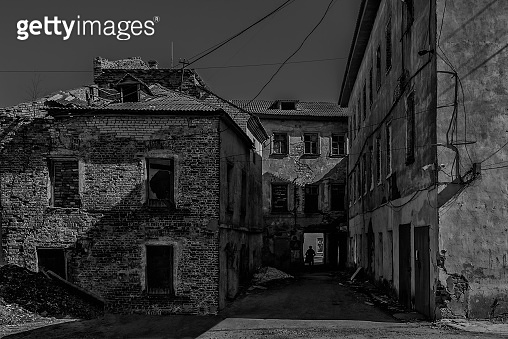 The yard of an abandoned old brick building at night in the moonlight ...