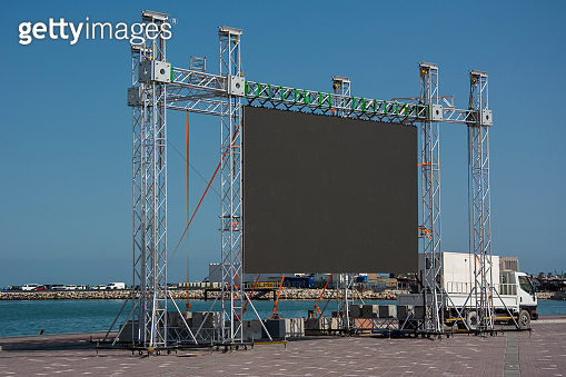 Large blank open-air outdoor LED screen for public event on sea shore ...