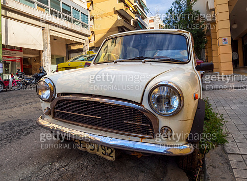 Old small car with round headlights on the street of the Greek capital ...
