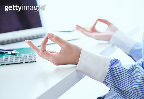 Calm businesswoman meditating at work, focus on female hands in mudra ...