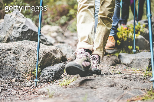 Legs view of people doing trekking excursion in mountain's path - Group ...