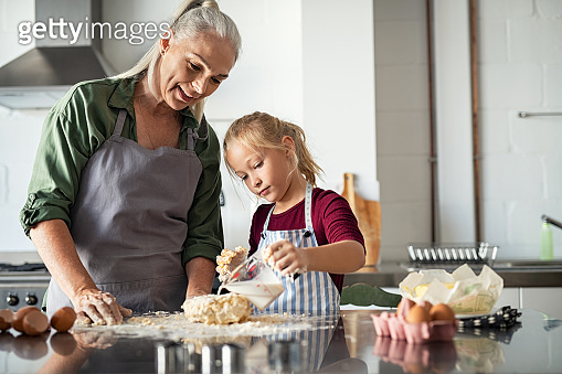 Little cute girl adding milk in dough 이미지 (1161412439) - 게티이미지뱅크