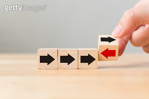 Hand flip over wooden cube block with red arrow facing the opposite ...