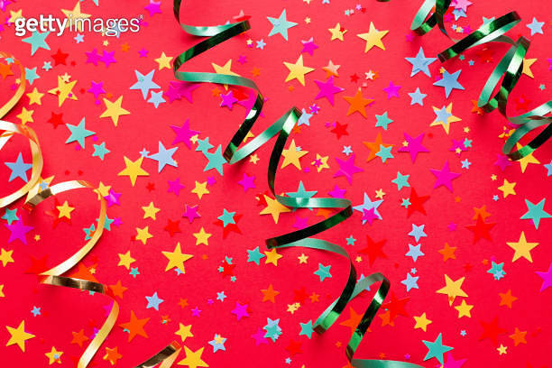 Festive red background with multicolor star shape confetti and ...