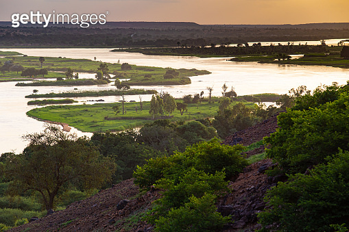 Evening pastel-coloured sky over meanders, islands and green shores of ...