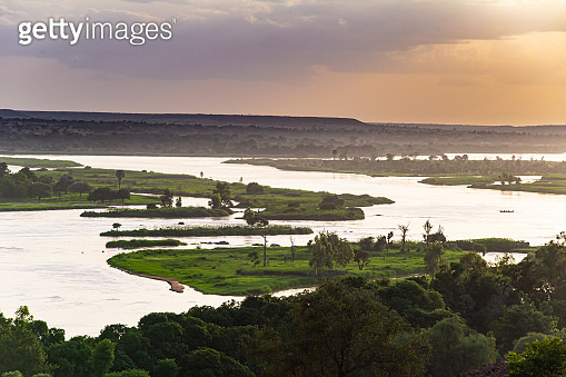 Evening pastel-coloured sky over meanders, islands and green shores of ...
