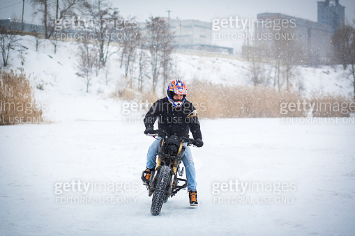 A guy rides a motorcycle on a frozen lake 이미지 (1171978796) - 게티이미지뱅크