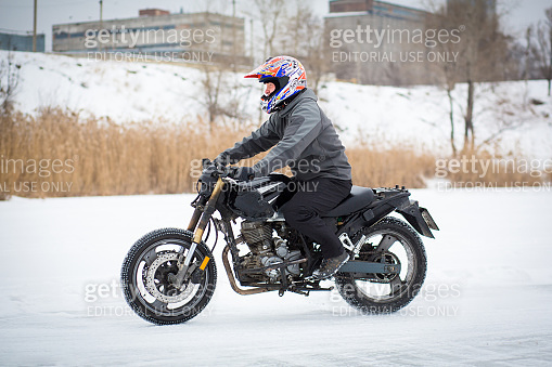 A guy rides a motorcycle on a frozen lake (1167050784) - 게티이미지뱅크