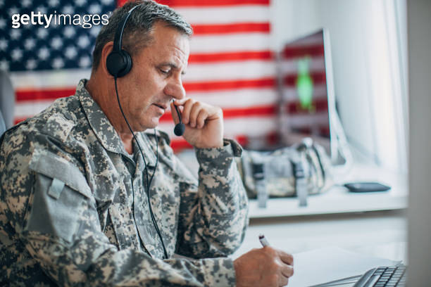 Army soldier wearing headphones and writing notes (1153609811) - 게티이미지뱅크