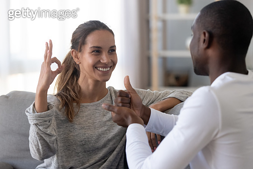 Happy mixed race deaf couple using sign language for communication 이미지 ...