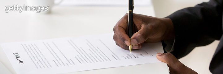 Closeup african businessman hands holds pen affirming contract with ...