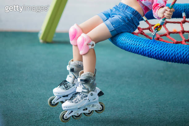 Close up photo of little girl's legs on roller skates at a park ...