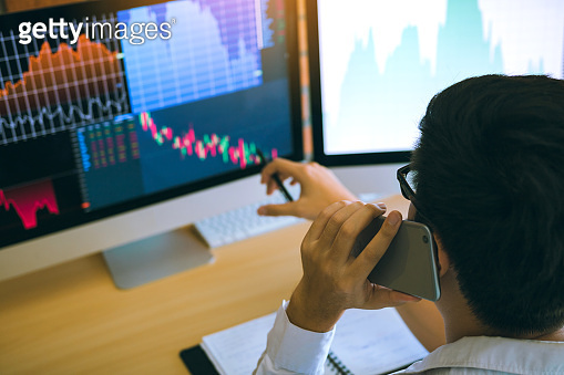 Agent trader man talking at telephone and checking business stock data ...