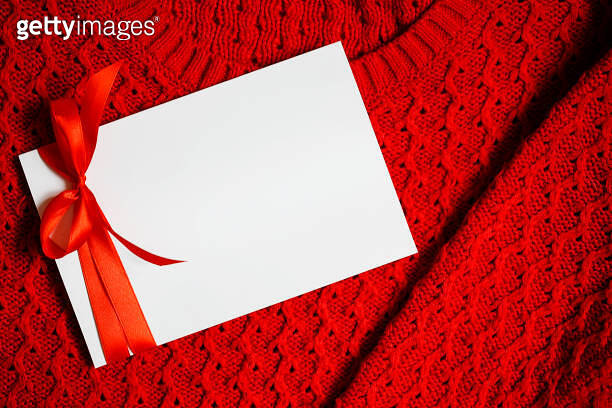 Empty white greeting cards or wish list with ribbon on knitted ...