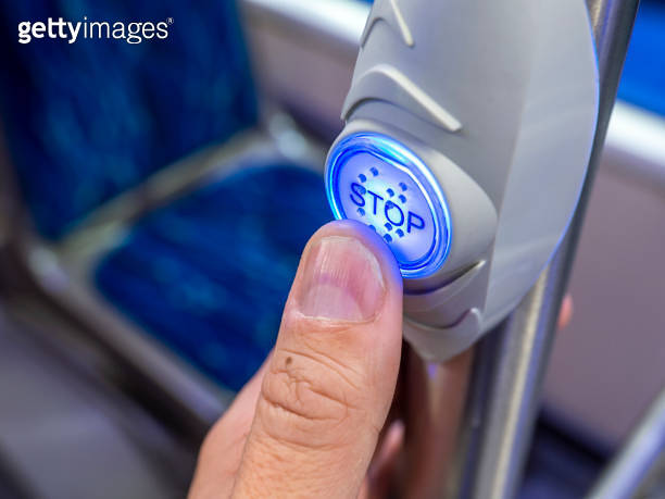 The finger of an adult person's hand presses the stop button for the ...