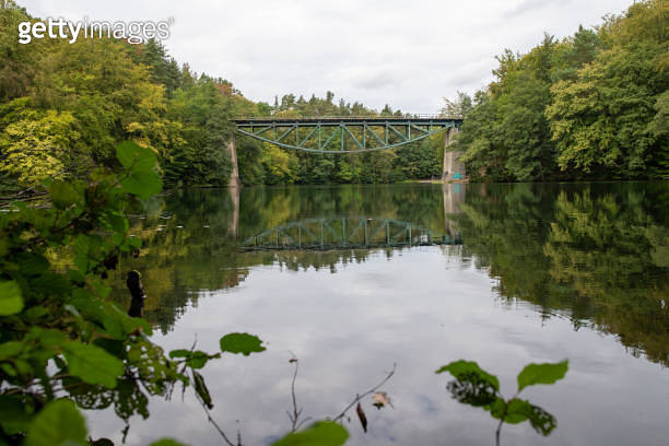 The railway bridge seen from the backwaters on the river. Steel river ...