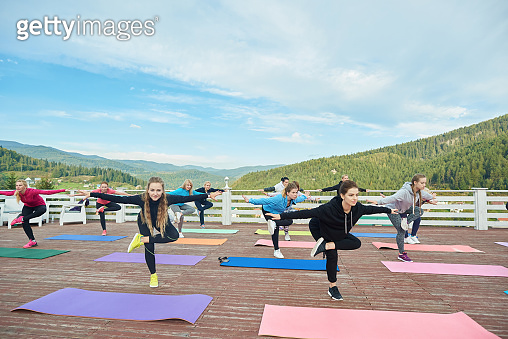 Yoga group doing balance exercises on one leg. 이미지 (1147521260) - 게티이미지뱅크