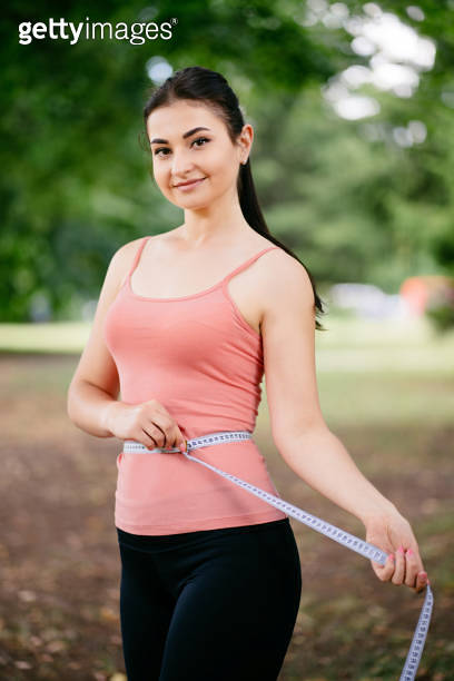 Woman with slim body measuring her waistline 이미지 (1164678750) - 게티이미지뱅크