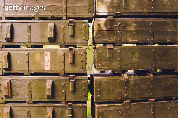 Military green boxes with dangerous explosives, guns and military ...