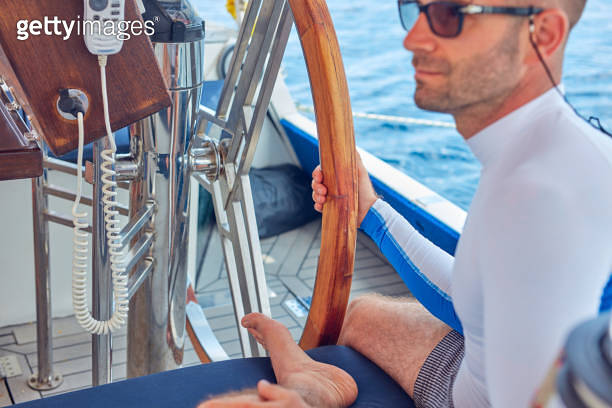 Sailor using wheel to steer rudder on a sailing boat. 이미지 (1166163667 ...