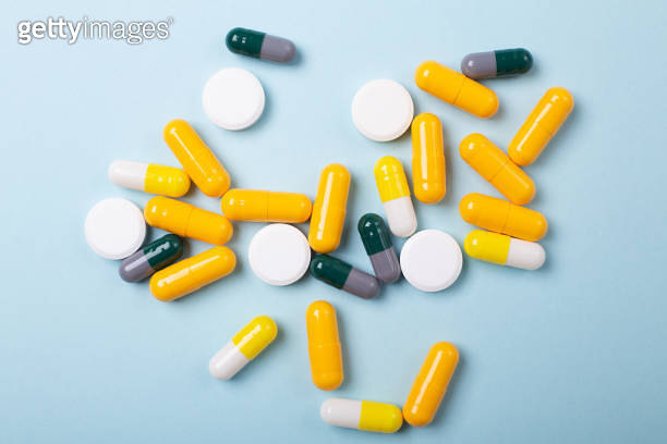 Multicolor tablets and pills capsules on blue background Close-up 이미지 ...