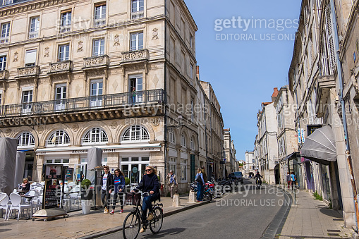 Residents of the city and tourists relax in a cafe on a street in the ...