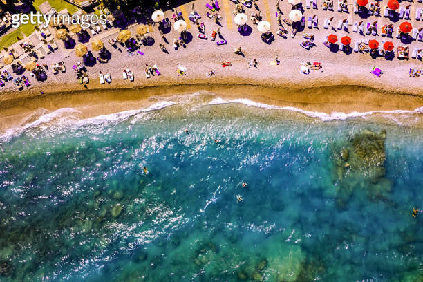 beach with umbrellas and sunbeds, resting people with clean water and ...