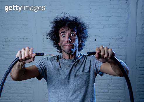Man getting electric shock connecting broken electrical cables at home ...