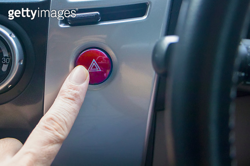 Emergency button in the car.finger hitting car emergency light button ...