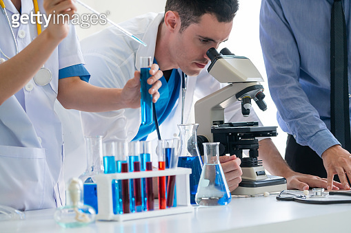 Group of scientists wearing lab coat working in laboratory while ...