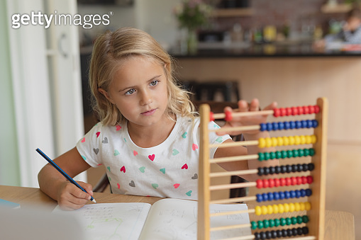 Girl doing homework at table in a comfortable home 이미지 (1156465771 ...