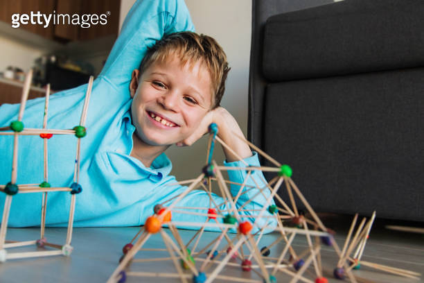 happy boy making geometric shapes from sticks and clay, engineering and ...