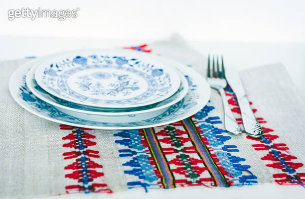 Table setting for dinner: plate, a fork, a knife on a woven cloth ...
