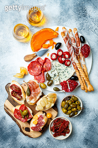 Appetizers table with antipasti snacks and wine in glasses. Brushetta ...