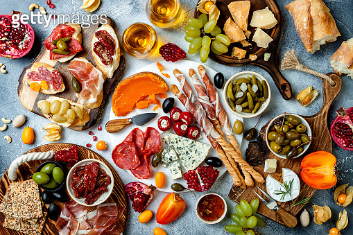 Appetizers table with antipasti snacks and wine in glasses. Brushetta ...