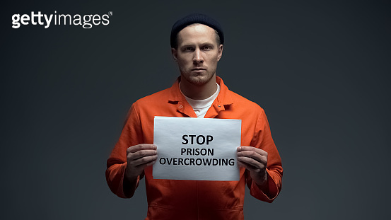 Prisoner holding Stop prison overcrowding sign in cell, life conditions ...