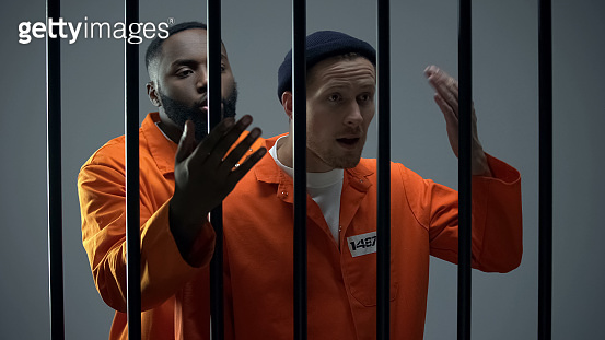 Black and caucasian inmate prisoners quarrelling with neighbors ...